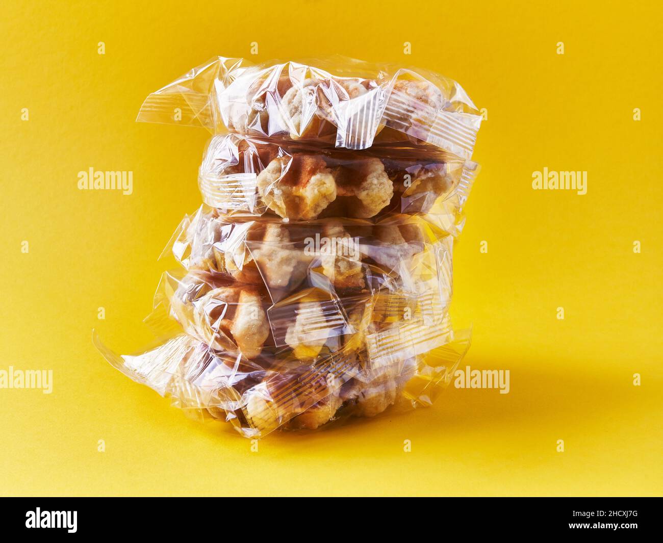 Bunch of delicious waffles wrapped on plastic bags over yellow ...