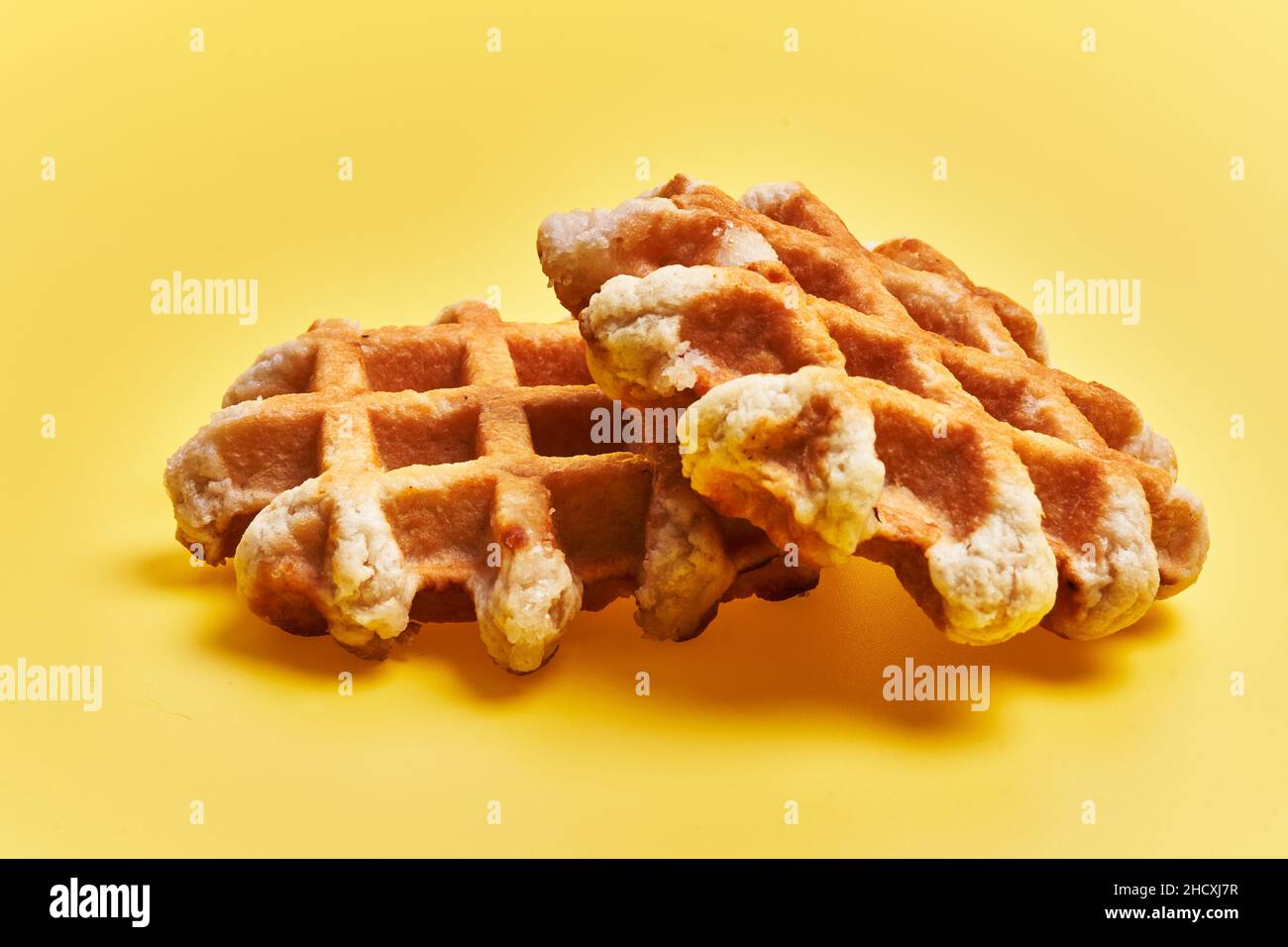 Two delicious waffles over yellow background Stock Photo - Alamy