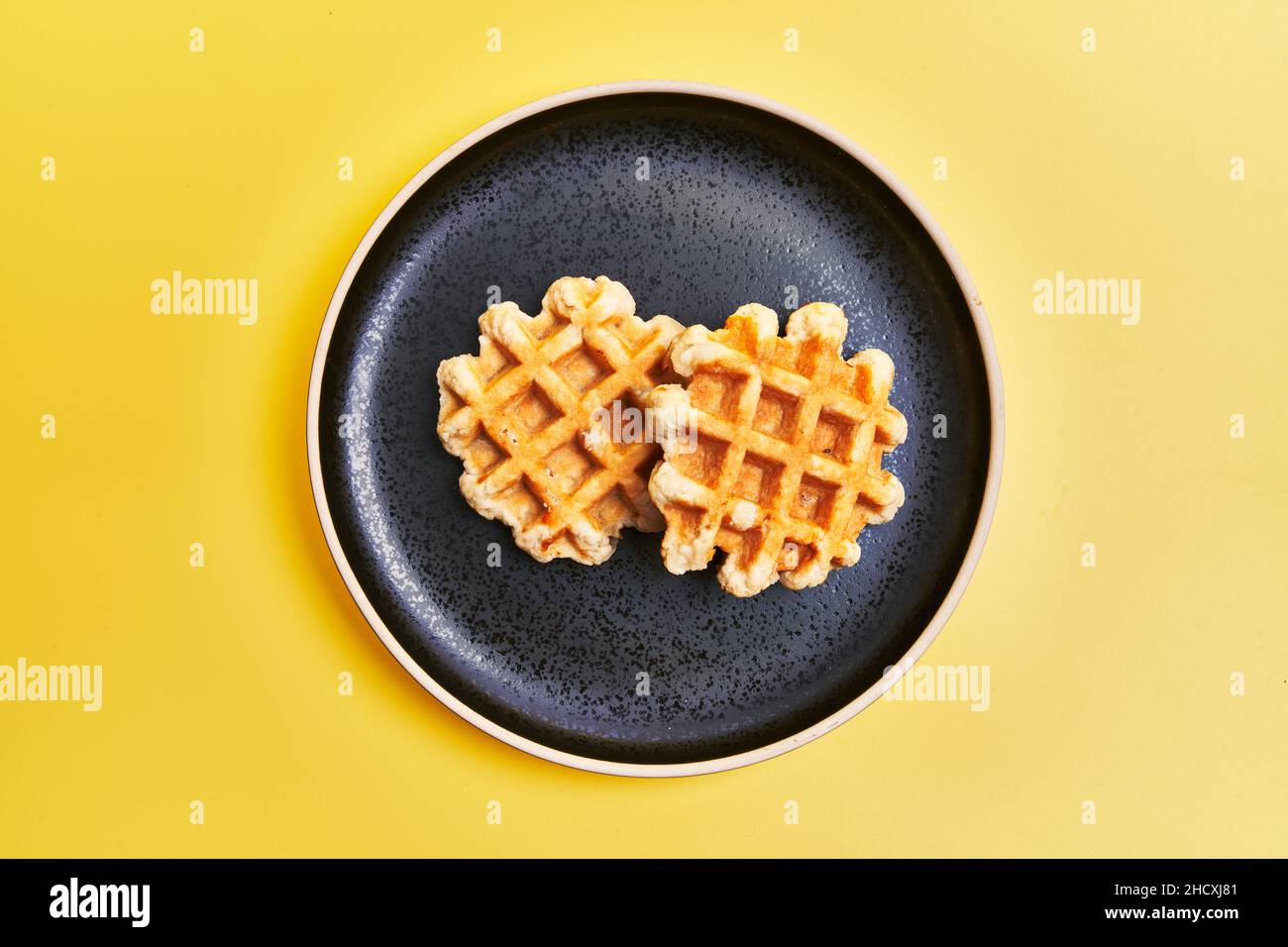 Plate of delicious waffles over yellow background Stock Photo - Alamy