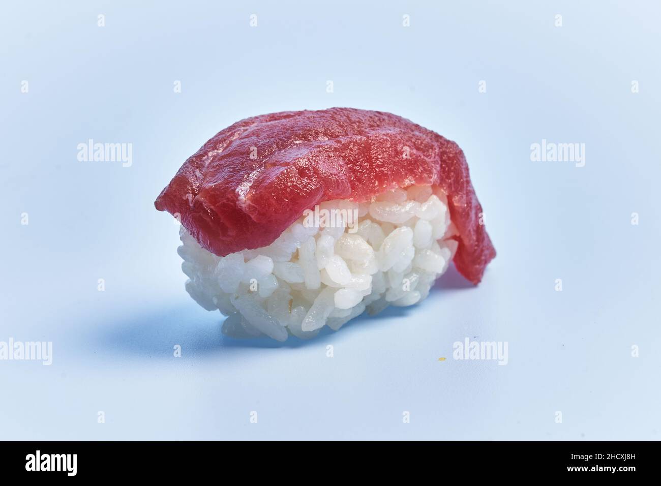 Single tuna nigiri sushi over blue background Stock Photo - Alamy