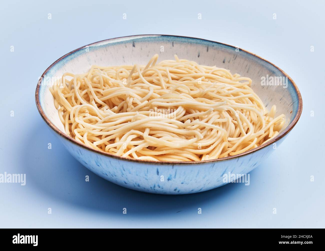 Plate of white spaghetti over blue background Stock Photo - Alamy