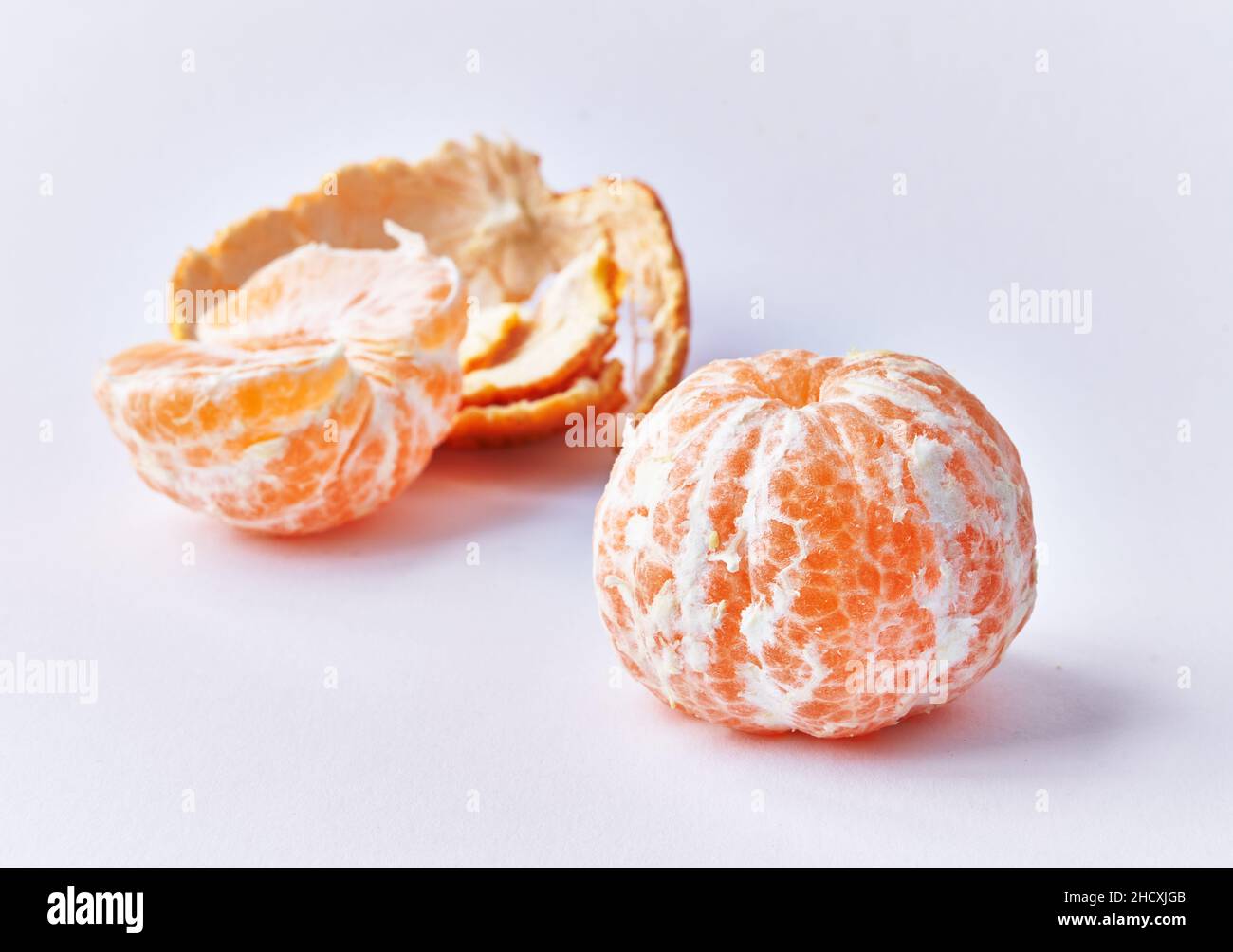 Two peeled tangerines isolated over white background Stock Photo - Alamy