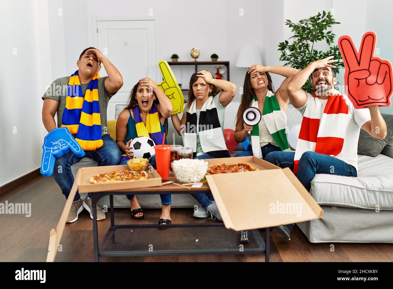 Group of young people wearing team scarf cheering football game ...