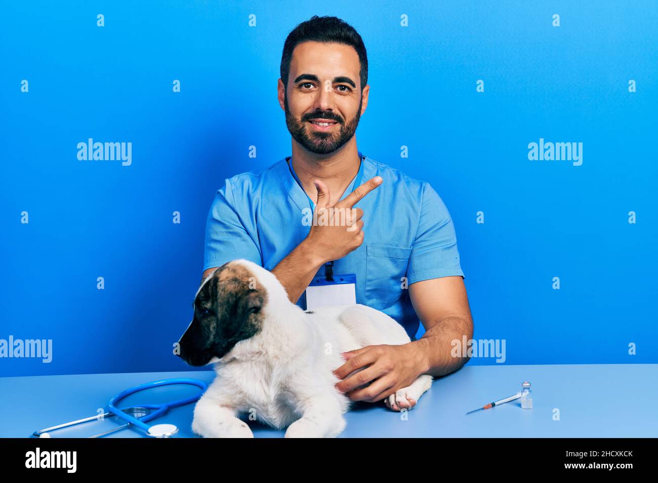 Handsome hispanic veterinary man with beard checking dog health ...
