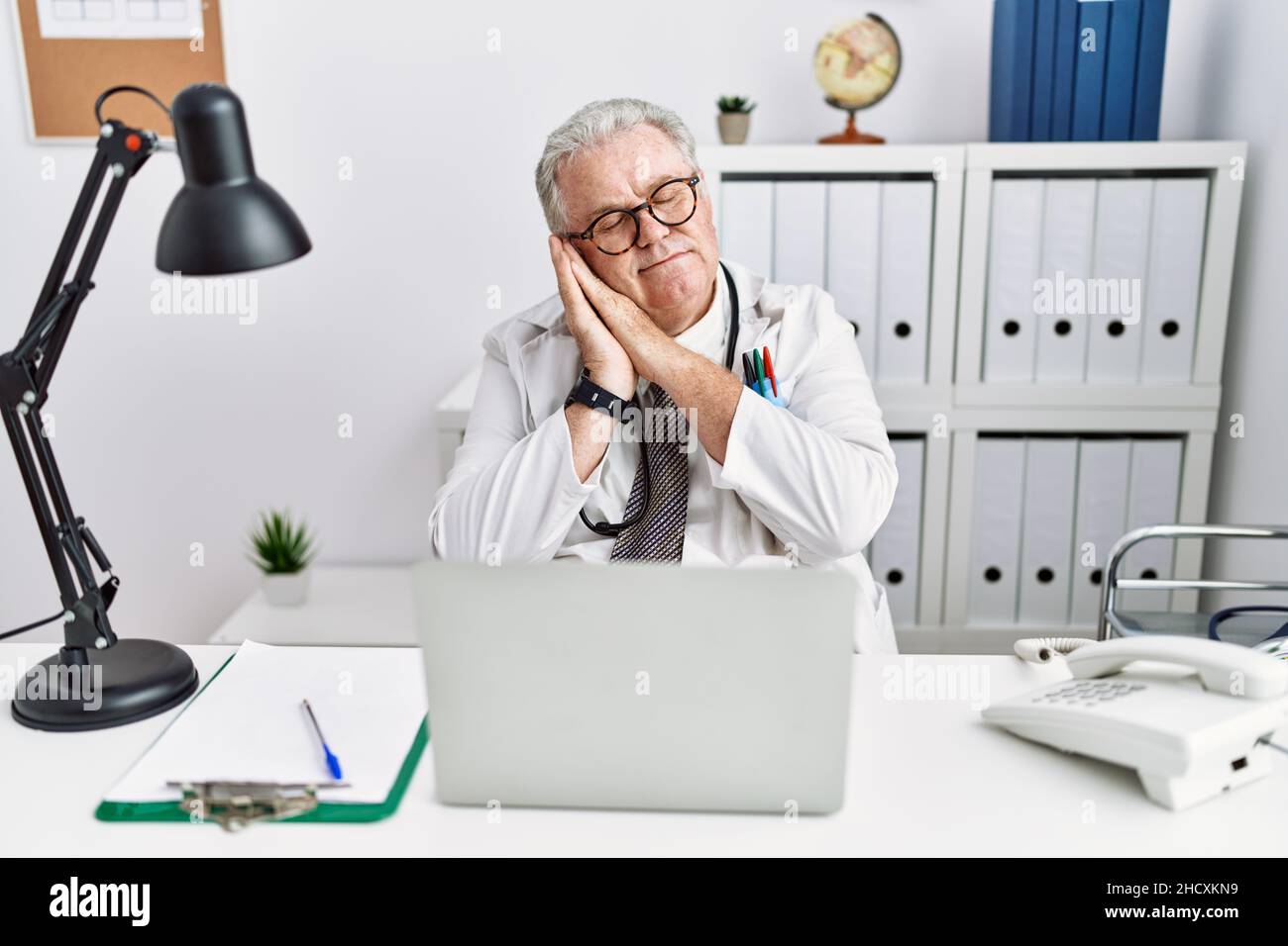 Senior caucasian man wearing doctor uniform and stethoscope at the ...