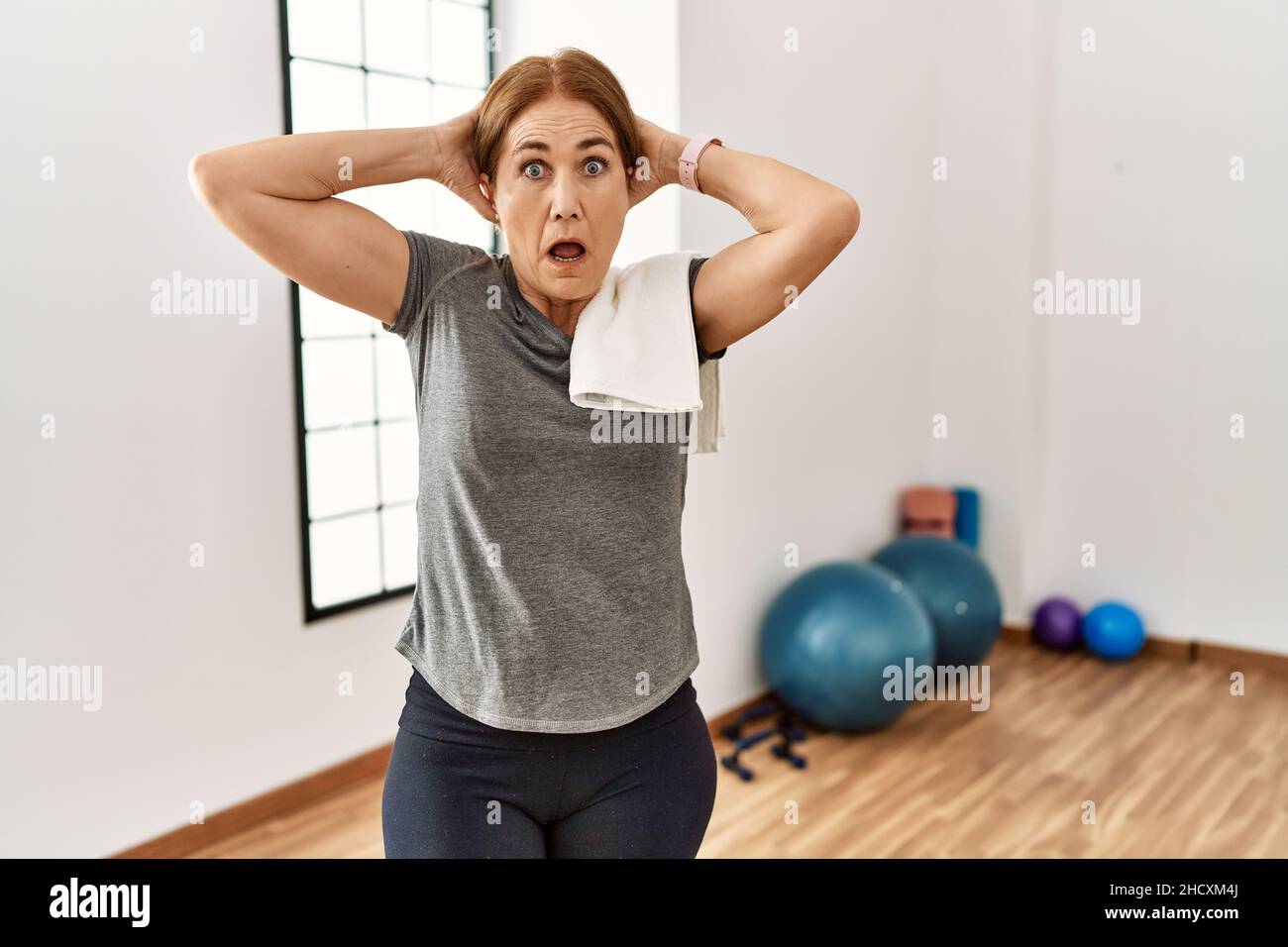 Middle age woman wearing sporty look training at the gym room crazy and ...
