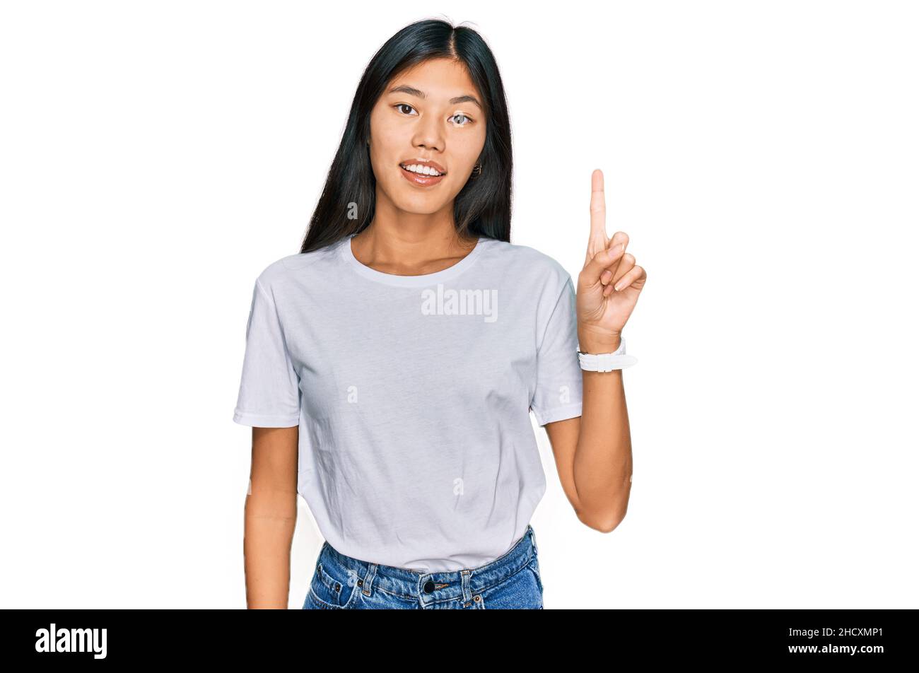 Beautiful young asian woman wearing casual white t shirt pointing ...