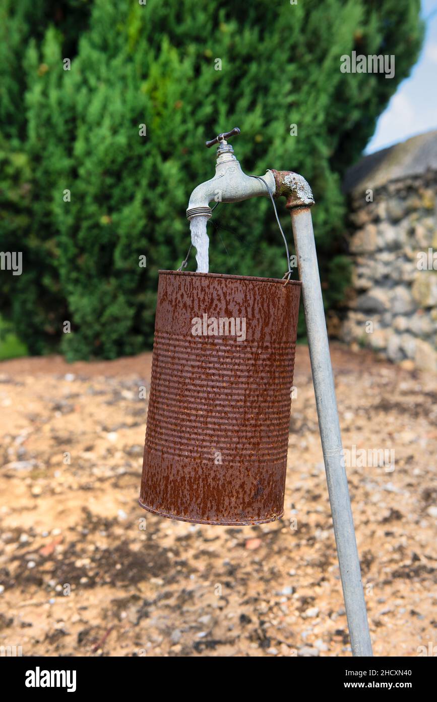 Old water tap with tin at the cementary Stock Photo - Alamy