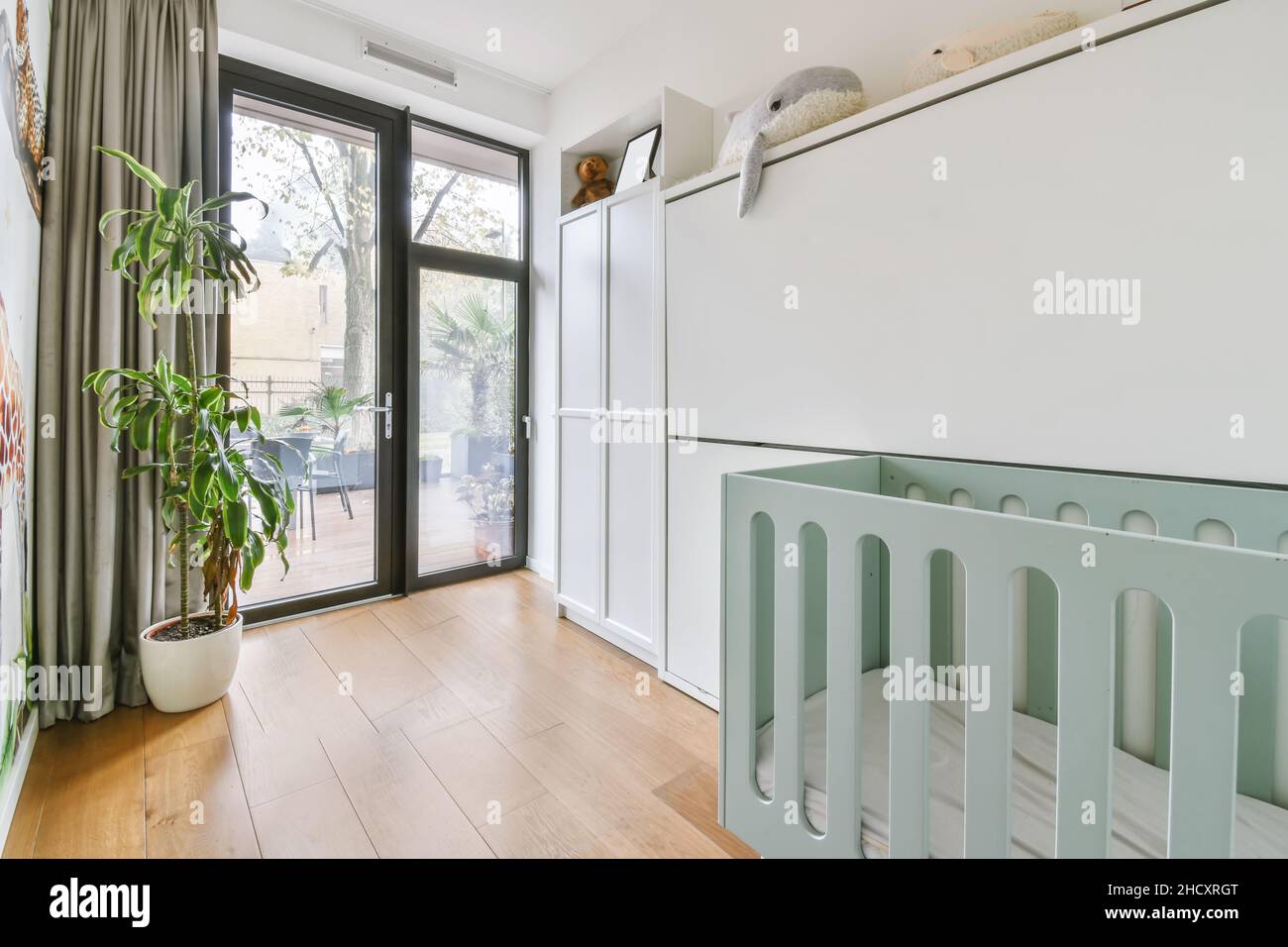 Superb kids room with wood parquet flooring and white walls Stock Photo ...
