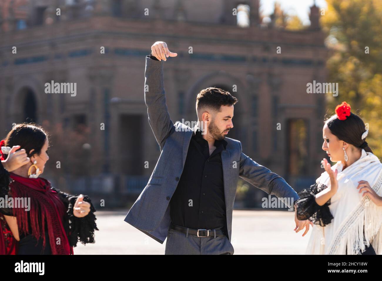 Man dancing flamenco next to two women in a square Stock Photo - Alamy