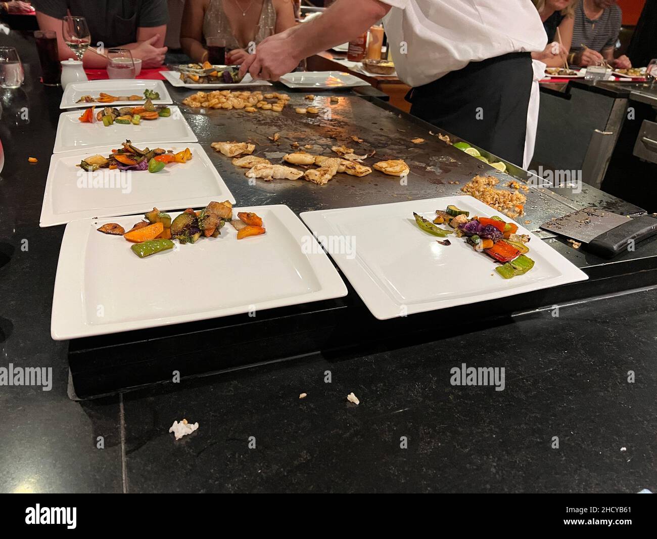 Diners waiting for chef in Japanese food teppanyaki restaurant. Dishes ...
