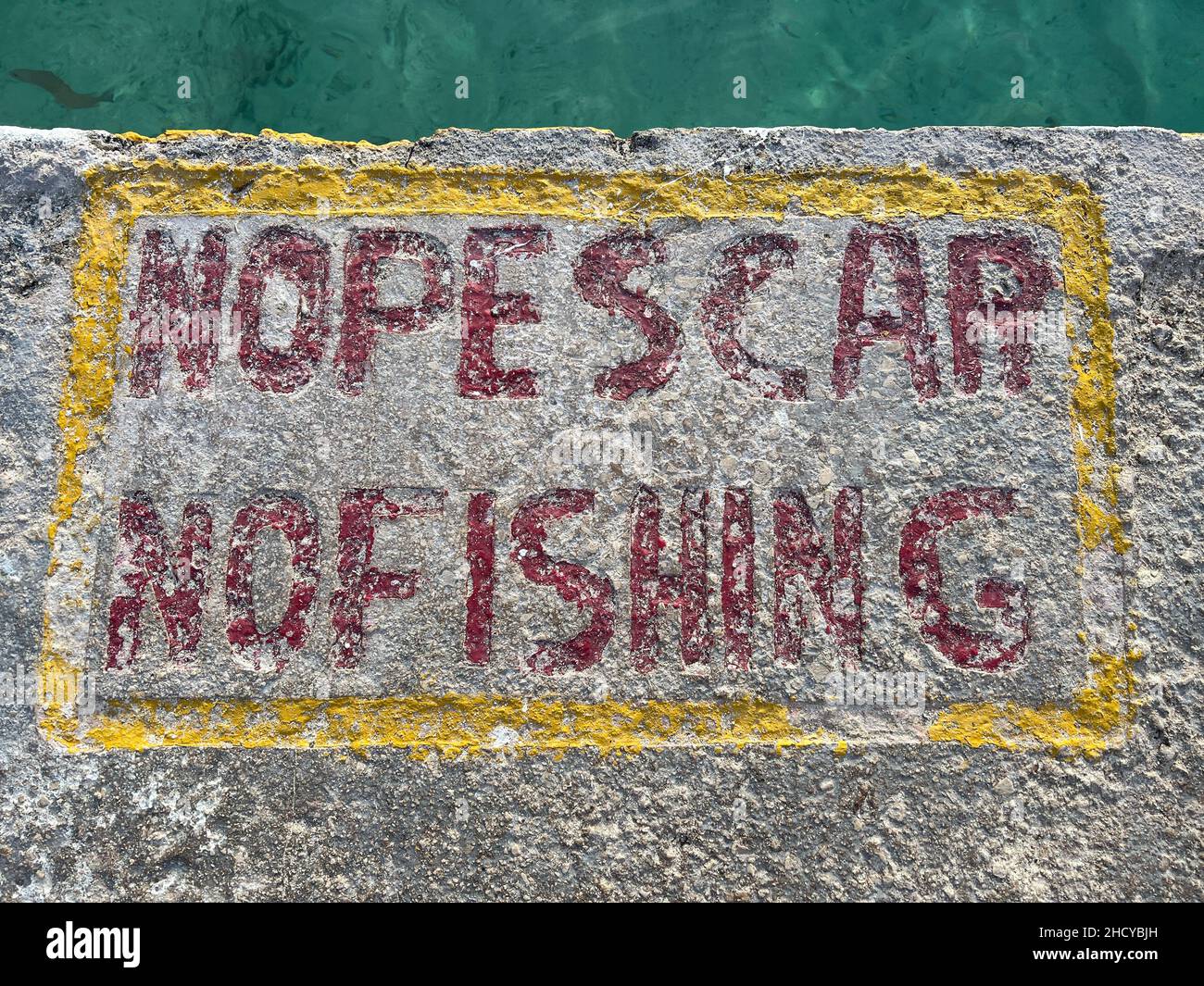 No fishing no pescar sign on a pier by the ocean. Warning sign to save ...