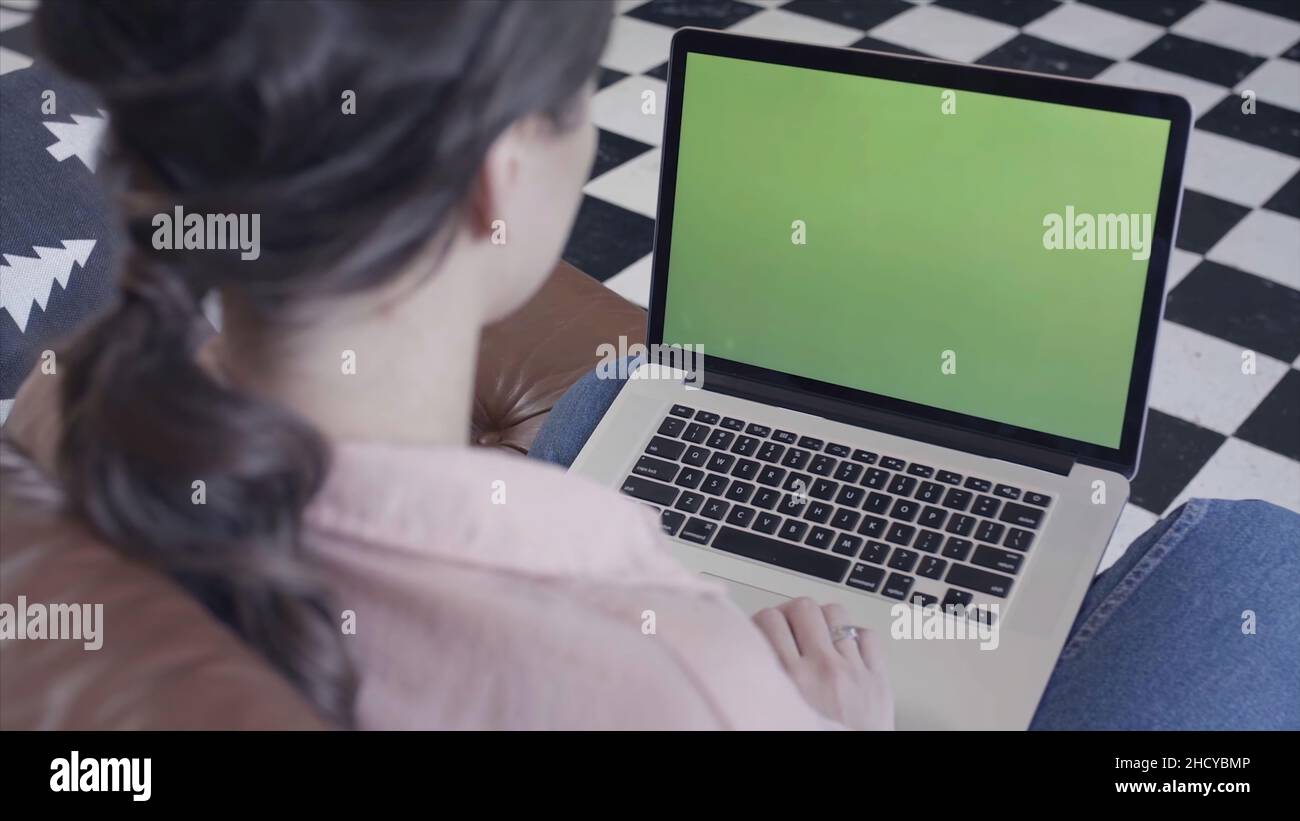 New technology concept. Young woman in pink at home typing on the ...