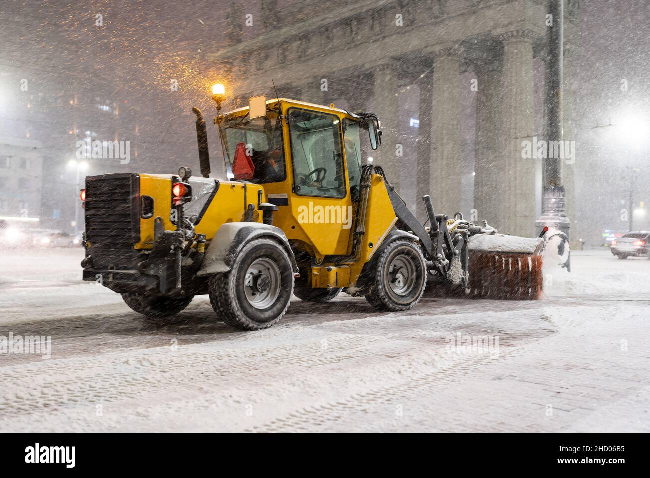 Winter service vehicles. Big yellow snow plow tractor working in city ...