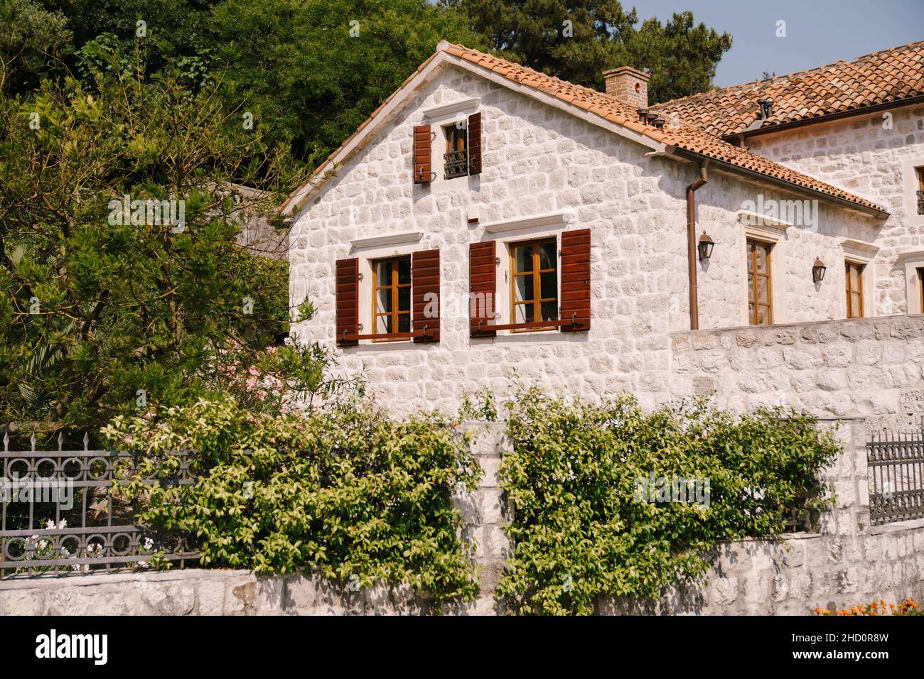 White stone building facade with brown wooden shutters on the windows ...