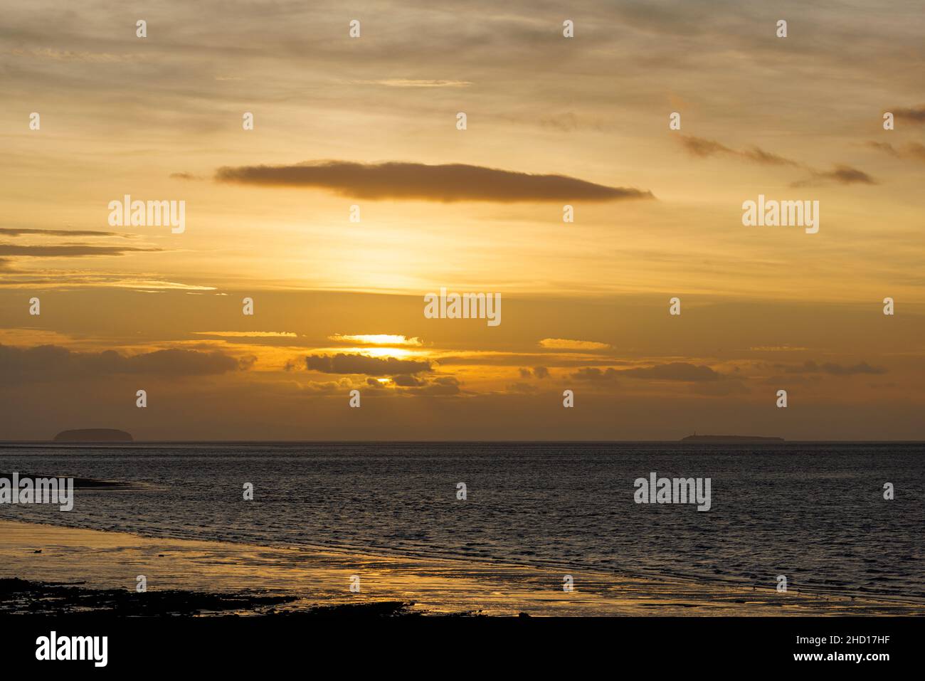 The setting sun turning the sky to a golden colour Stock Photo - Alamy
