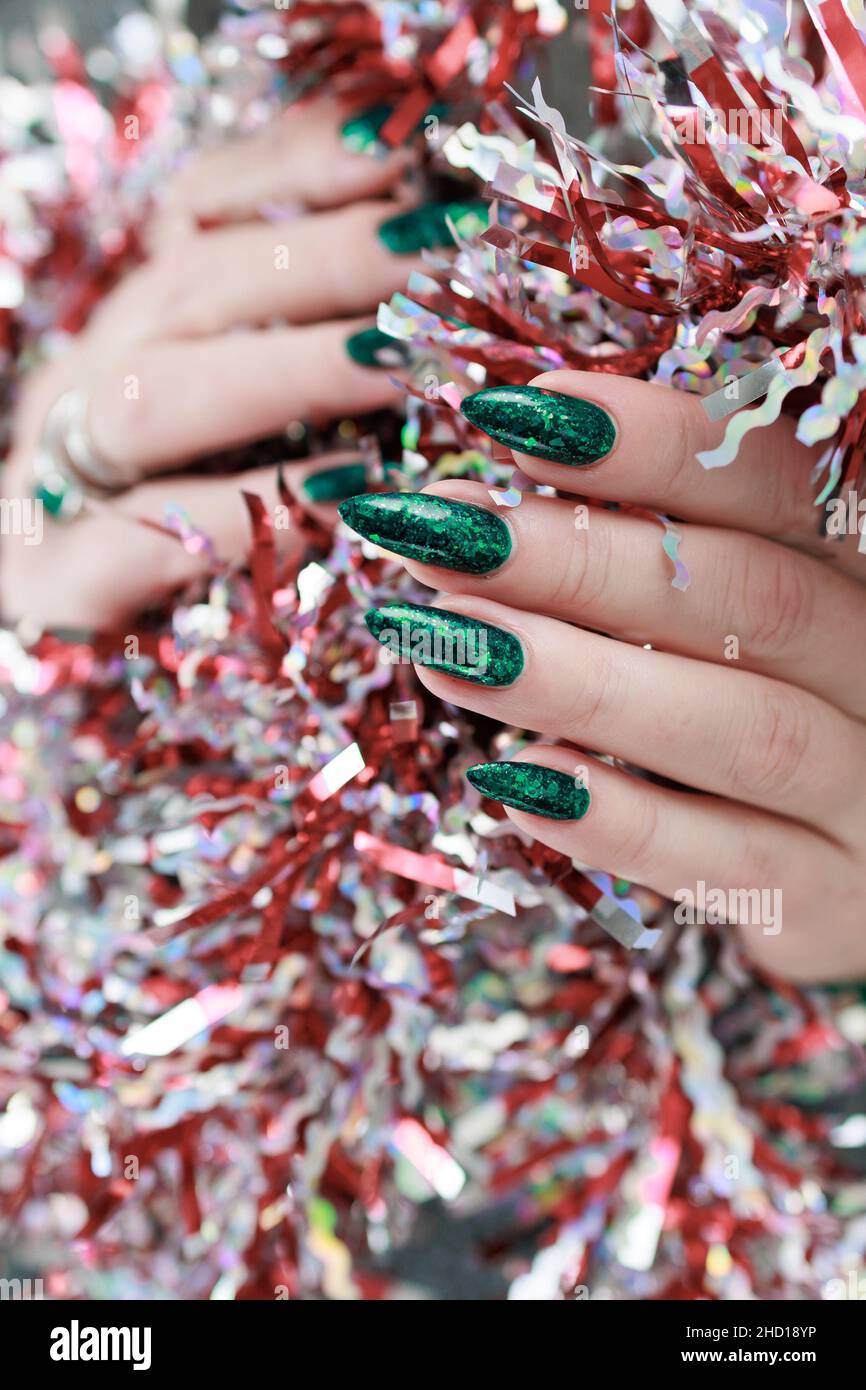Women's hands with long nails and bright green manicure ...