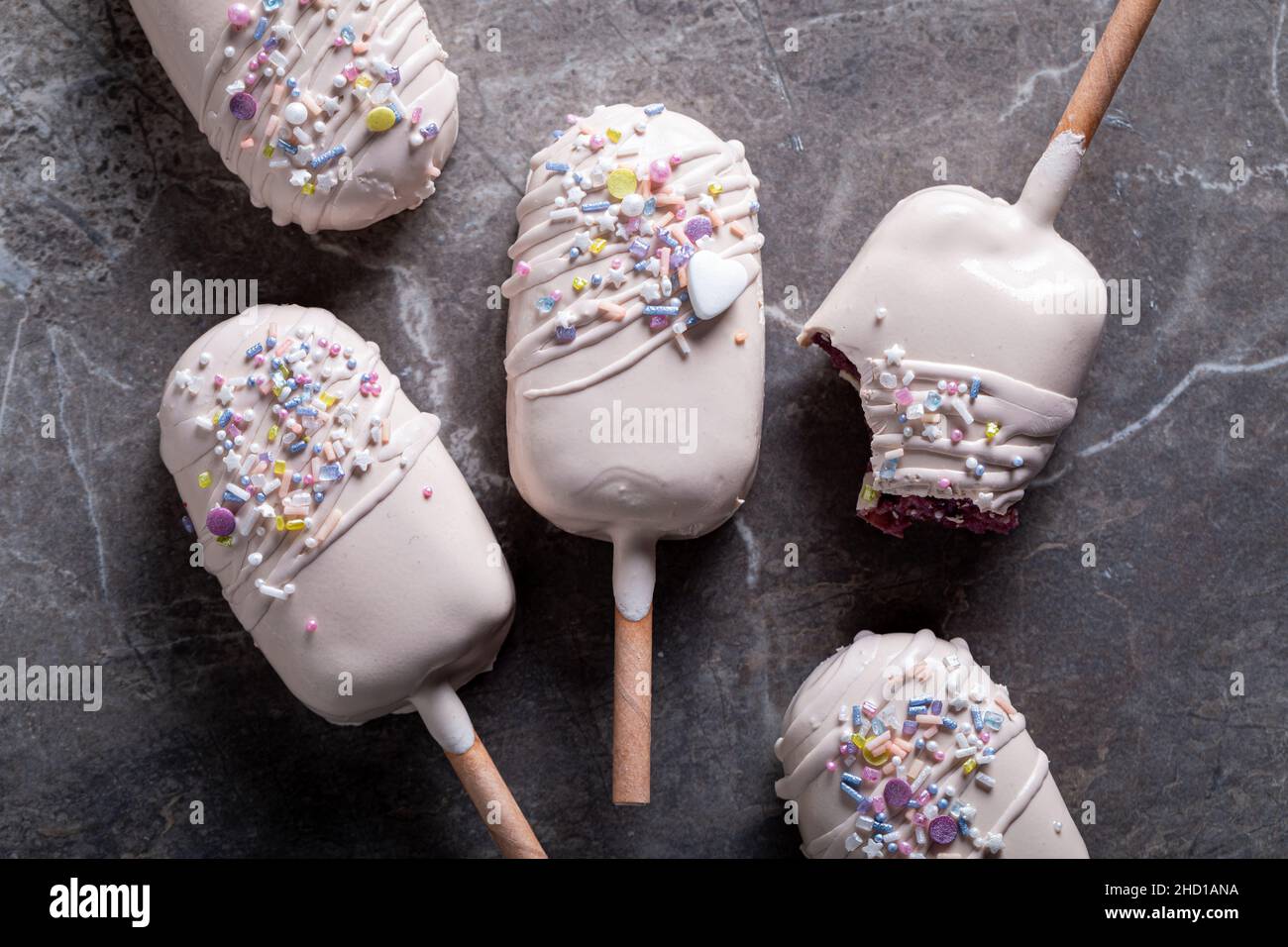 Cold and sweet popsicles looking like small ice cream on dark stone ...