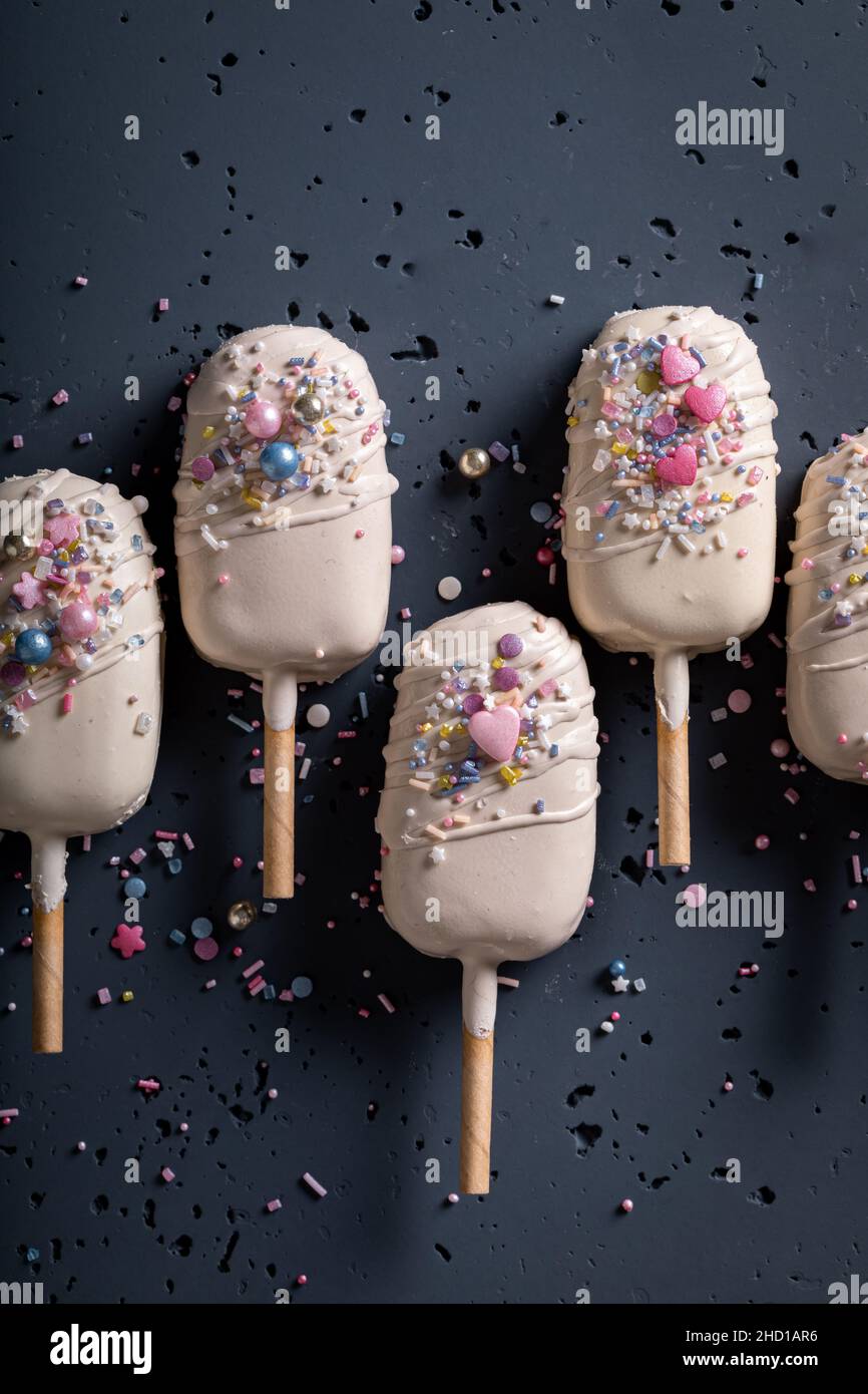 Homemade and cold popsicles looking like small ice cream on dark stone ...