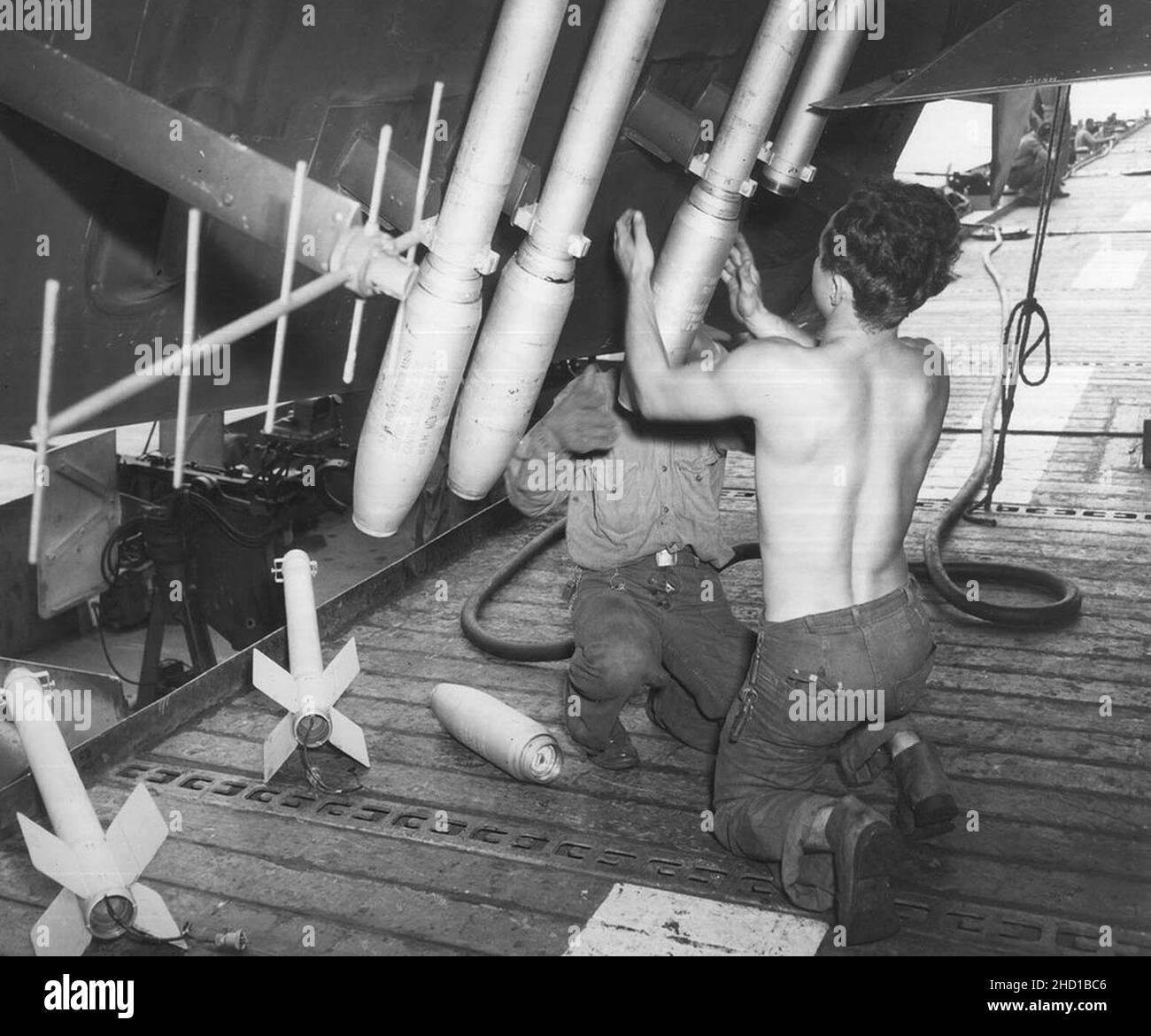 Rockets being loaded onto a TBM-3 Avenger torpedo bomber in support of ...