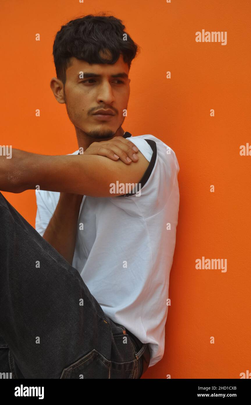 Side view of a handsome Indian guy looking sideways while sitting ...