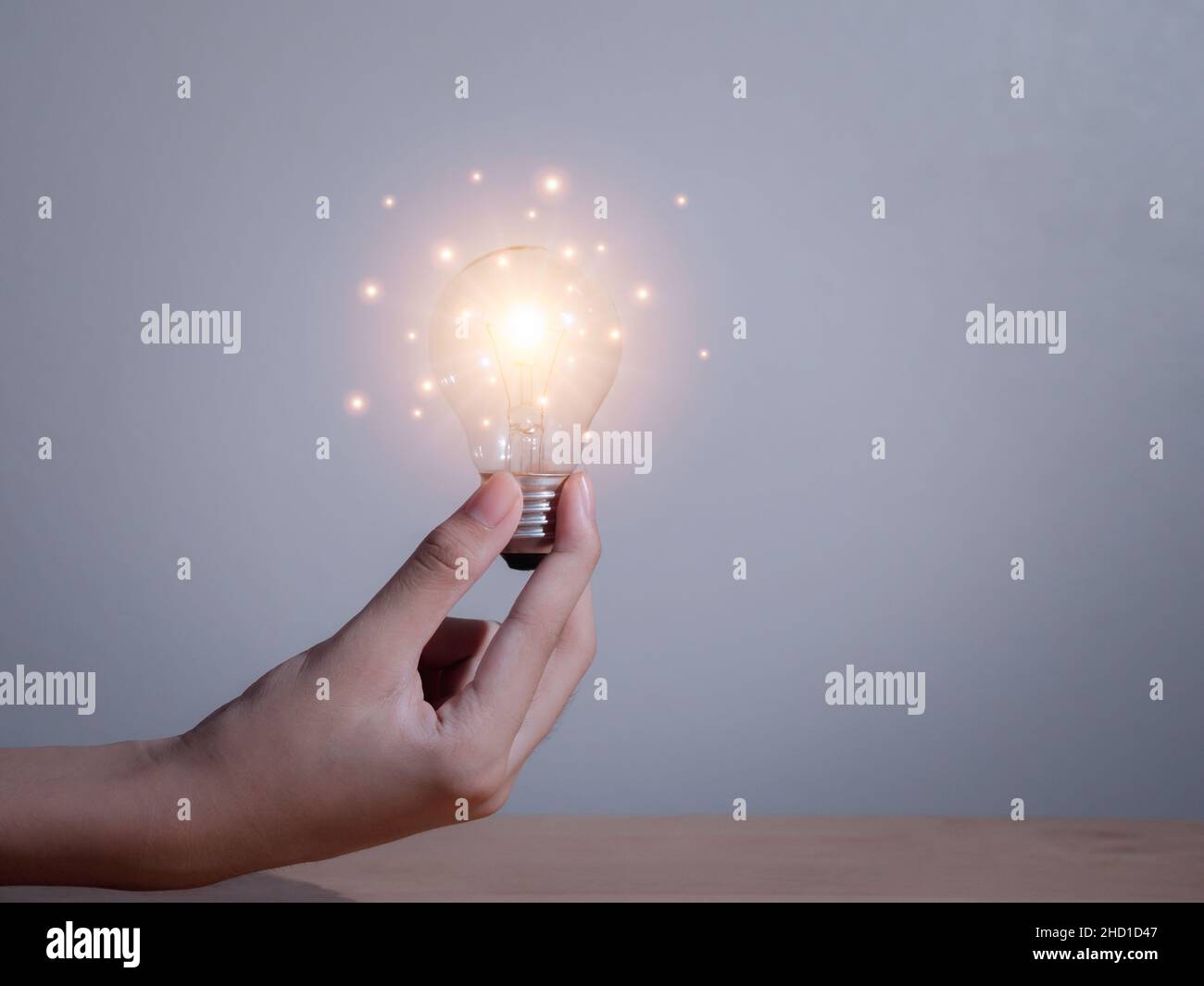 Hand of businessman holding light bulb with fire spark shine glitter ...