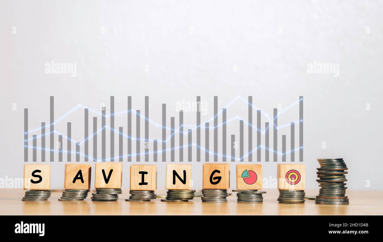 The word SAVING written from a wooden block or cube on coins stack with ...