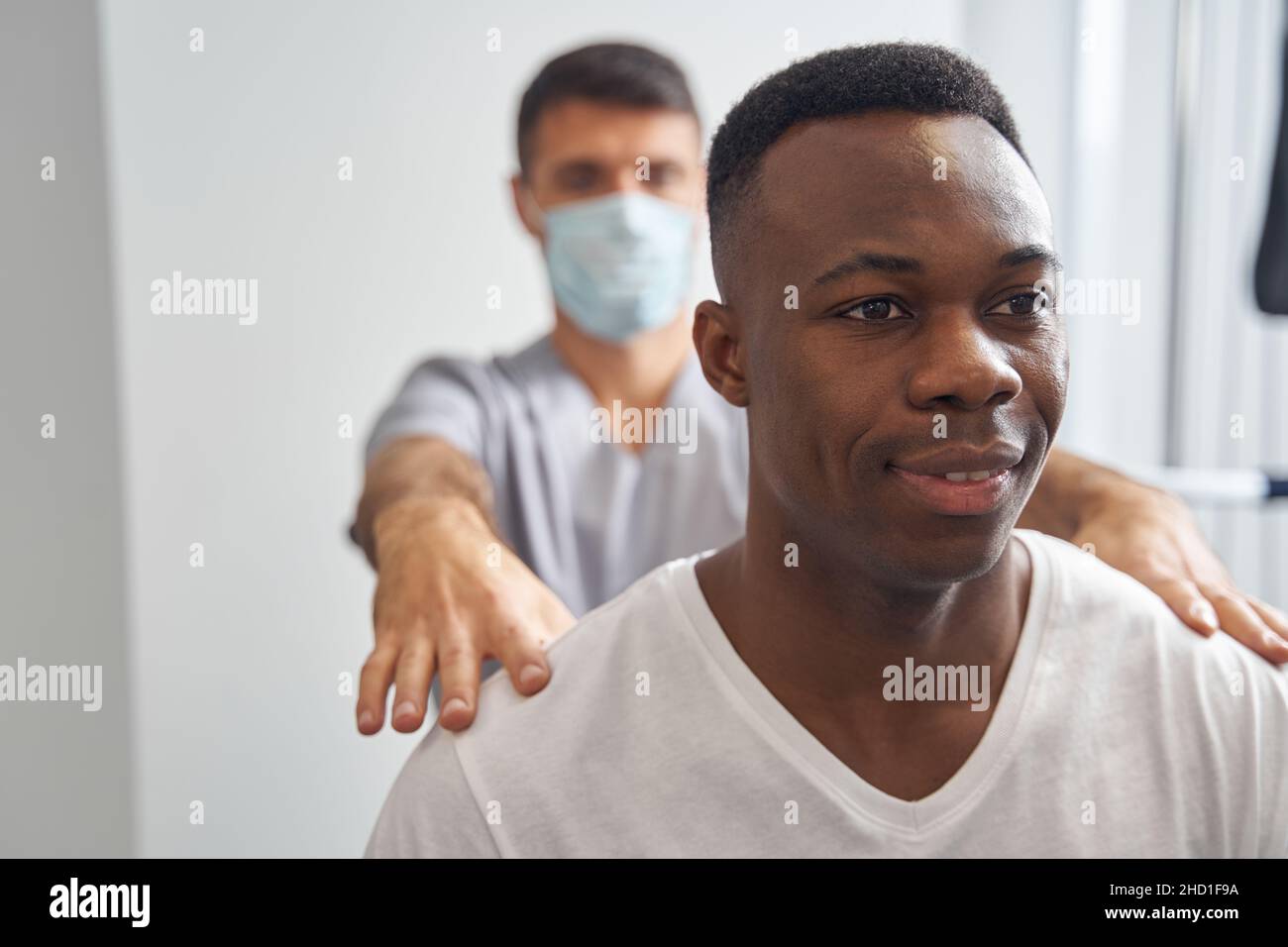 Pleased male patient standing during spine examination Stock Photo - Alamy
