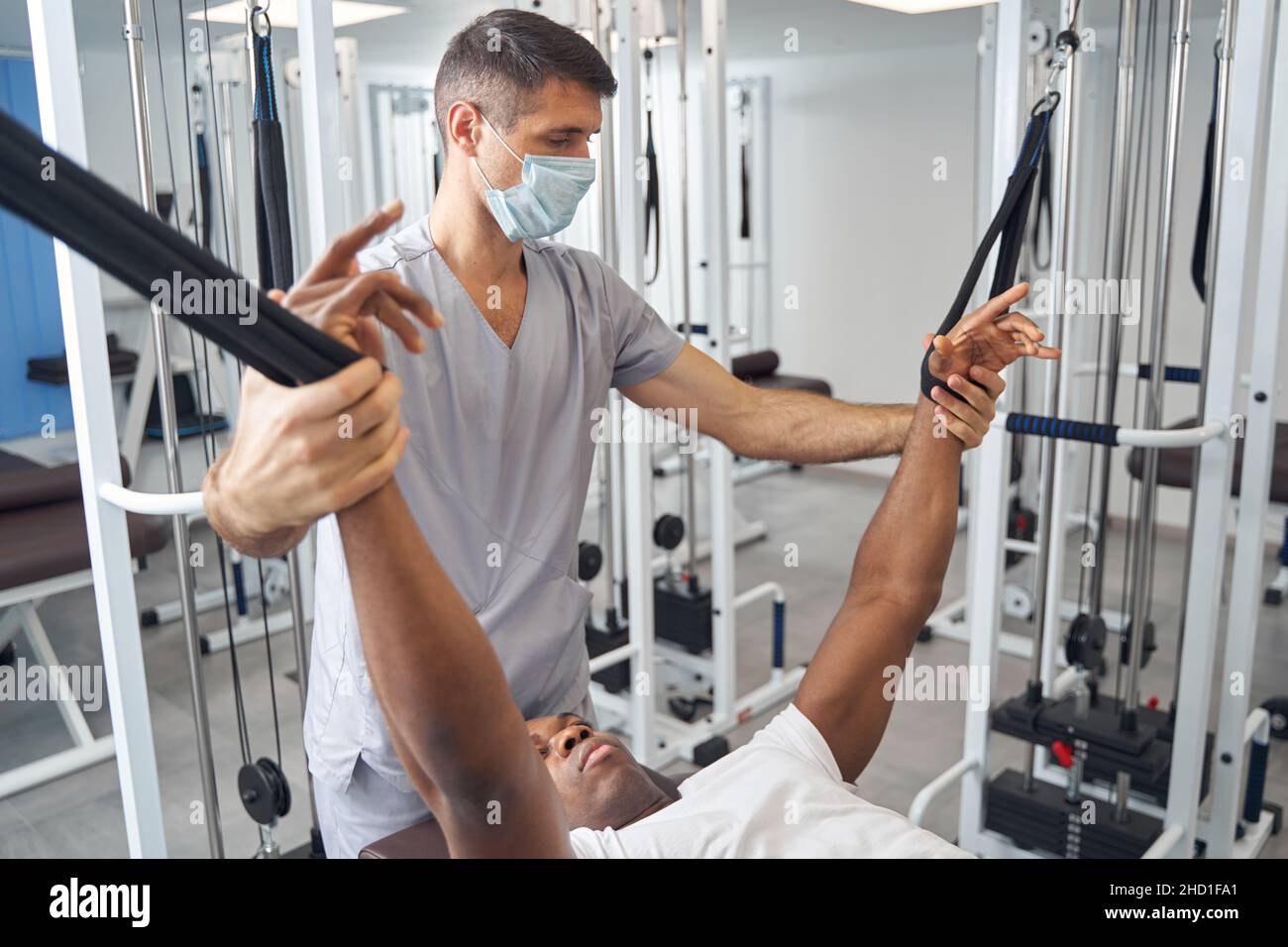 Rehabilitation physician working with patient at gym Stock Photo - Alamy