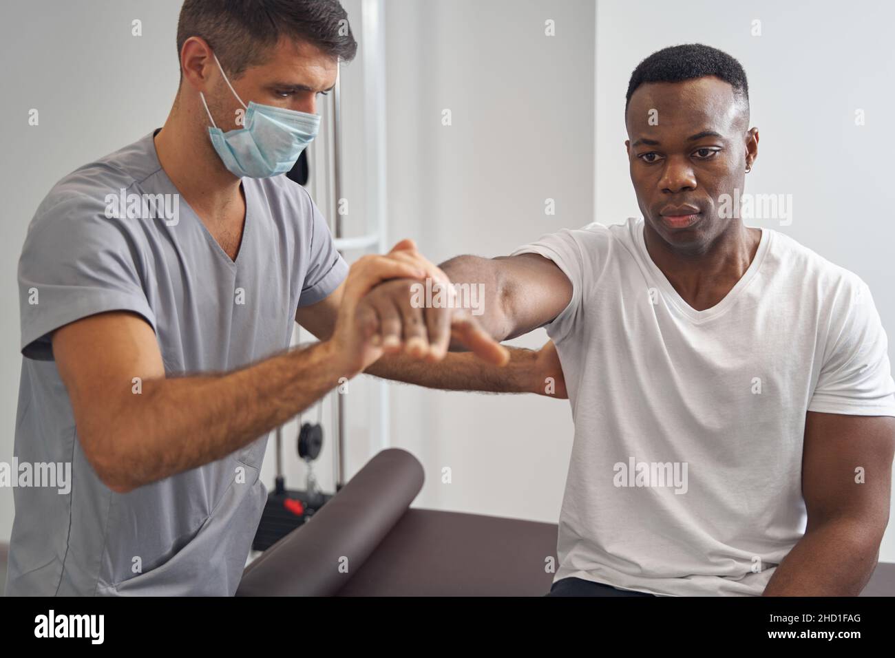 Patient being examined by physiotherapist during resisted isometric ...