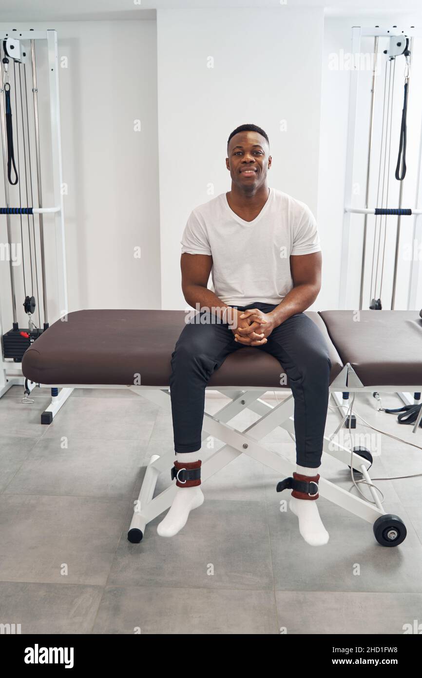 Joyous patient seated at gym looking ahead Stock Photo - Alamy