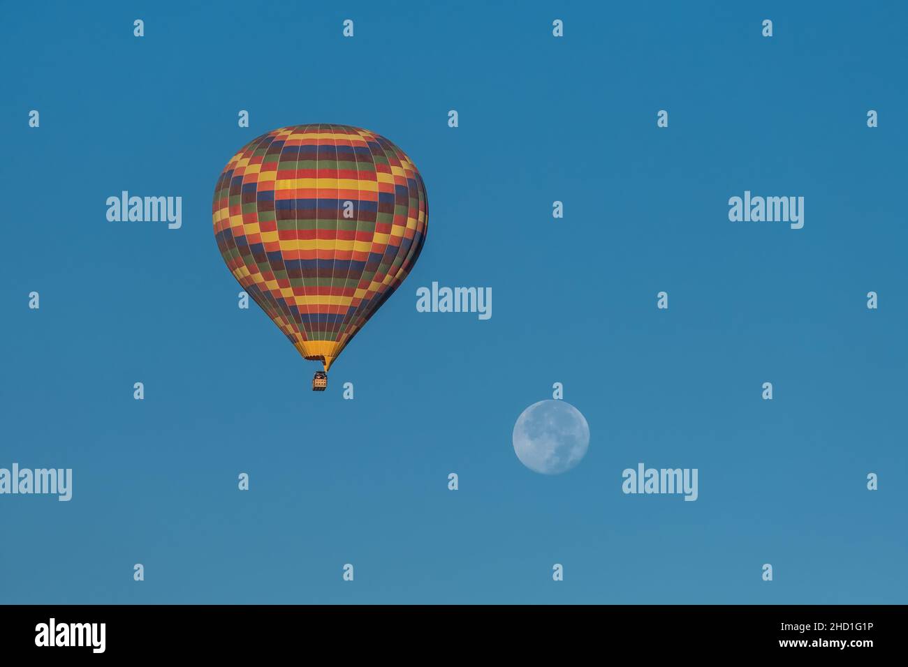 Colorful hot air balloon with the moon behind Stock Photo - Alamy