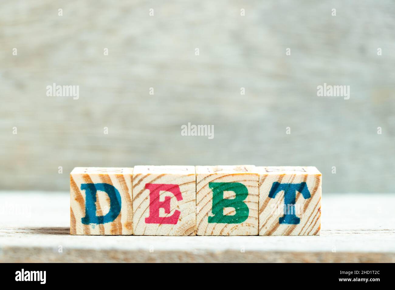 Alphabet letter block in word debt on wood background Stock Photo - Alamy
