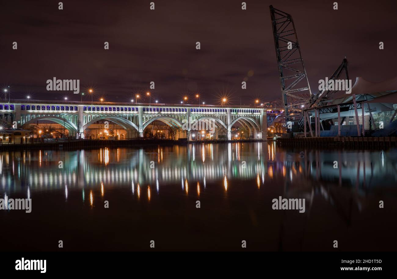 Water with a reflection if a lightened bridge at night Stock Photo - Alamy