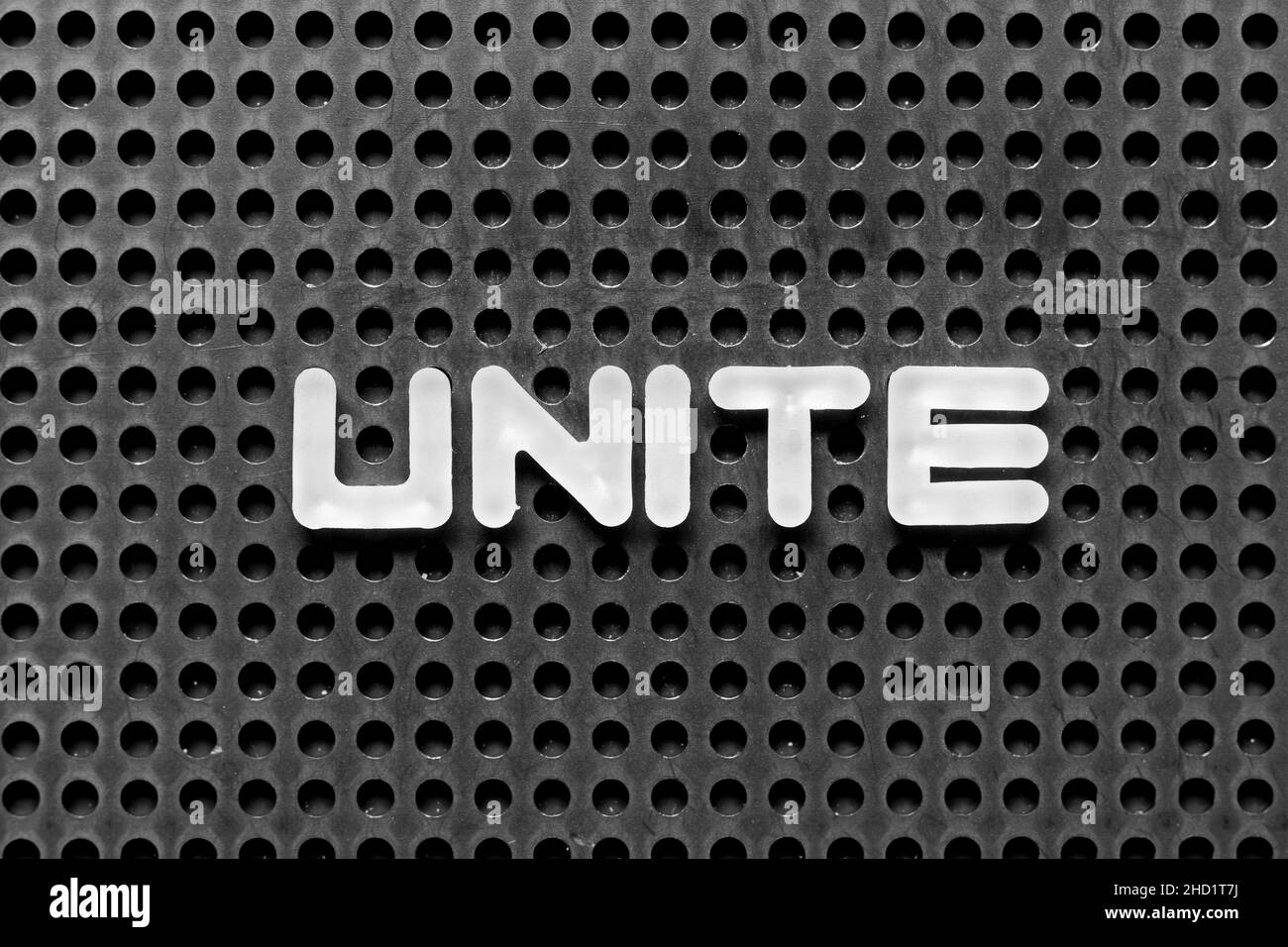 White alphabet letter in word unite on black pegboard background Stock ...