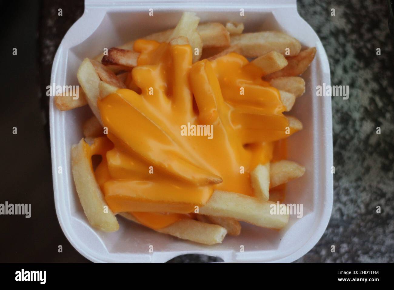 Delicious fresh cheese fries in the styrofoam container Stock Photo - Alamy