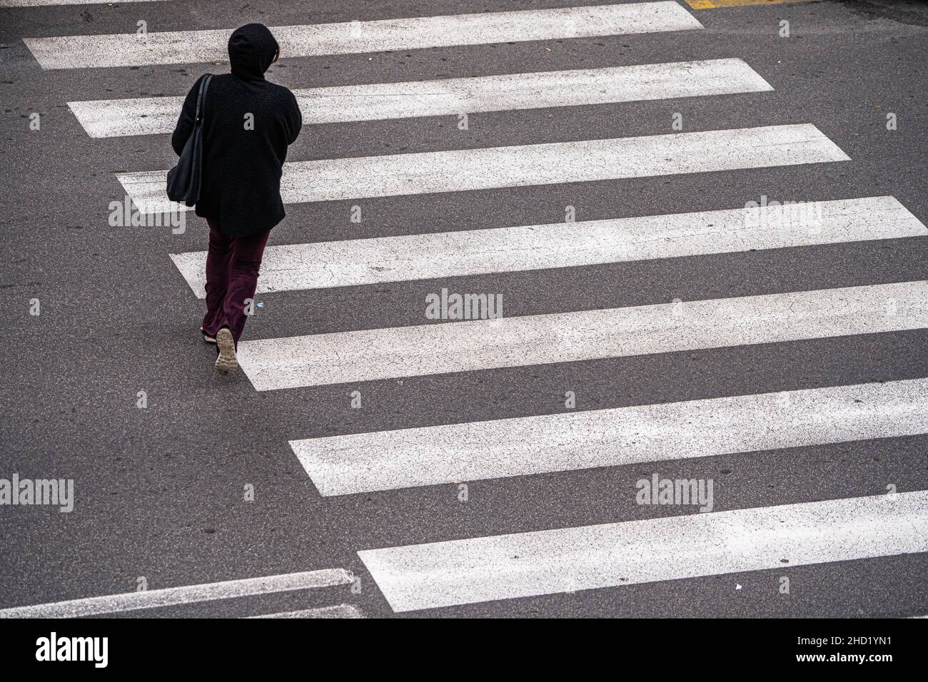 A pedestrian walking across a crosswalk in Rome, Italy Stock Photo - Alamy