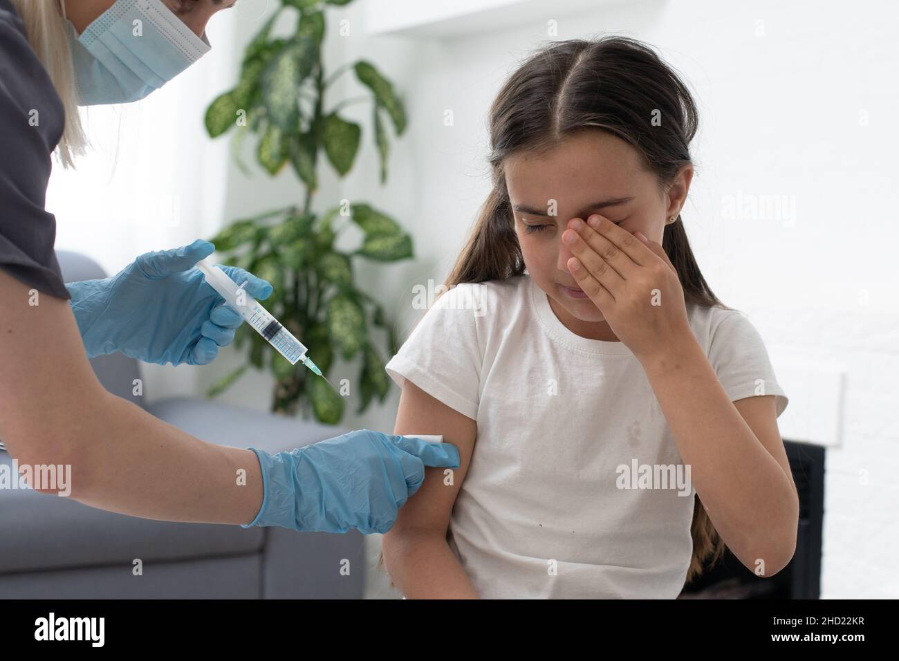 A little girl with tears in her eyes is very afraid of vaccination. The ...