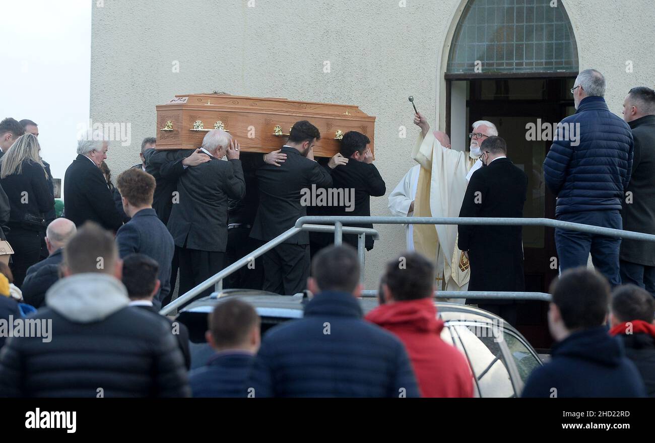 A priest sprinkles the coffin with holy water as it arrives for the ...