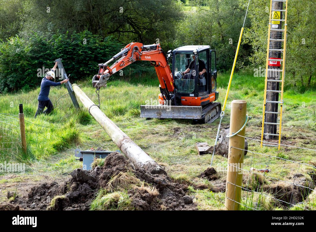 Western Power workers engineers and digger erecting a new utility pole ...