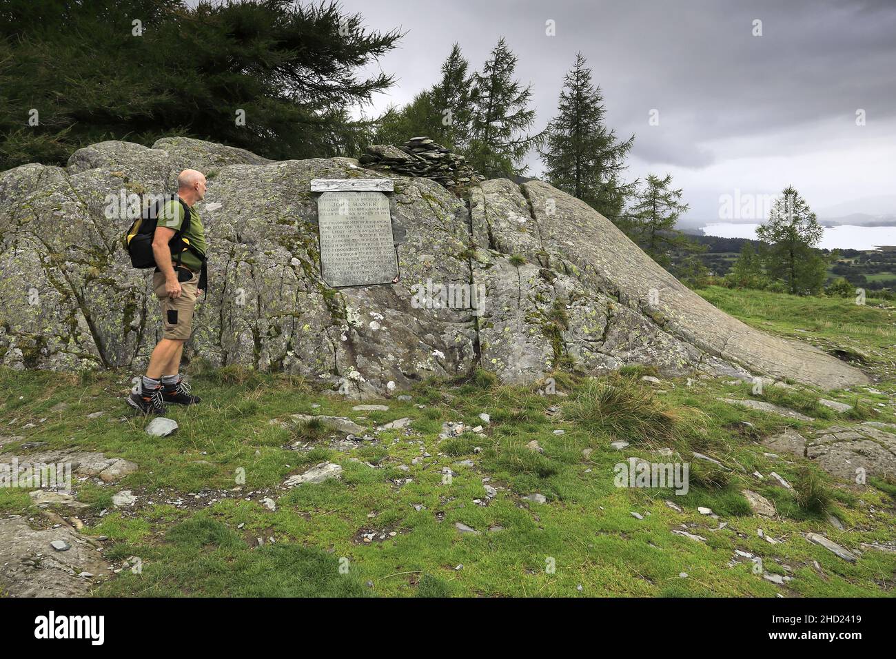 Walker at the summit cairn on Castle Crag fell above the Borrowdale ...
