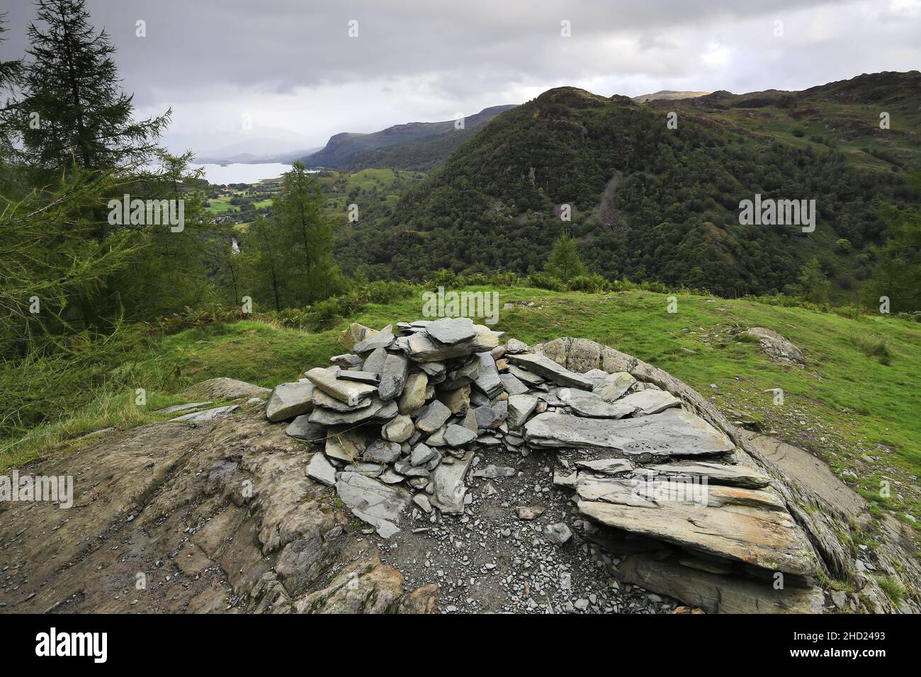 The summit cairn on Castle Crag fell above the Borrowdale pass valley ...