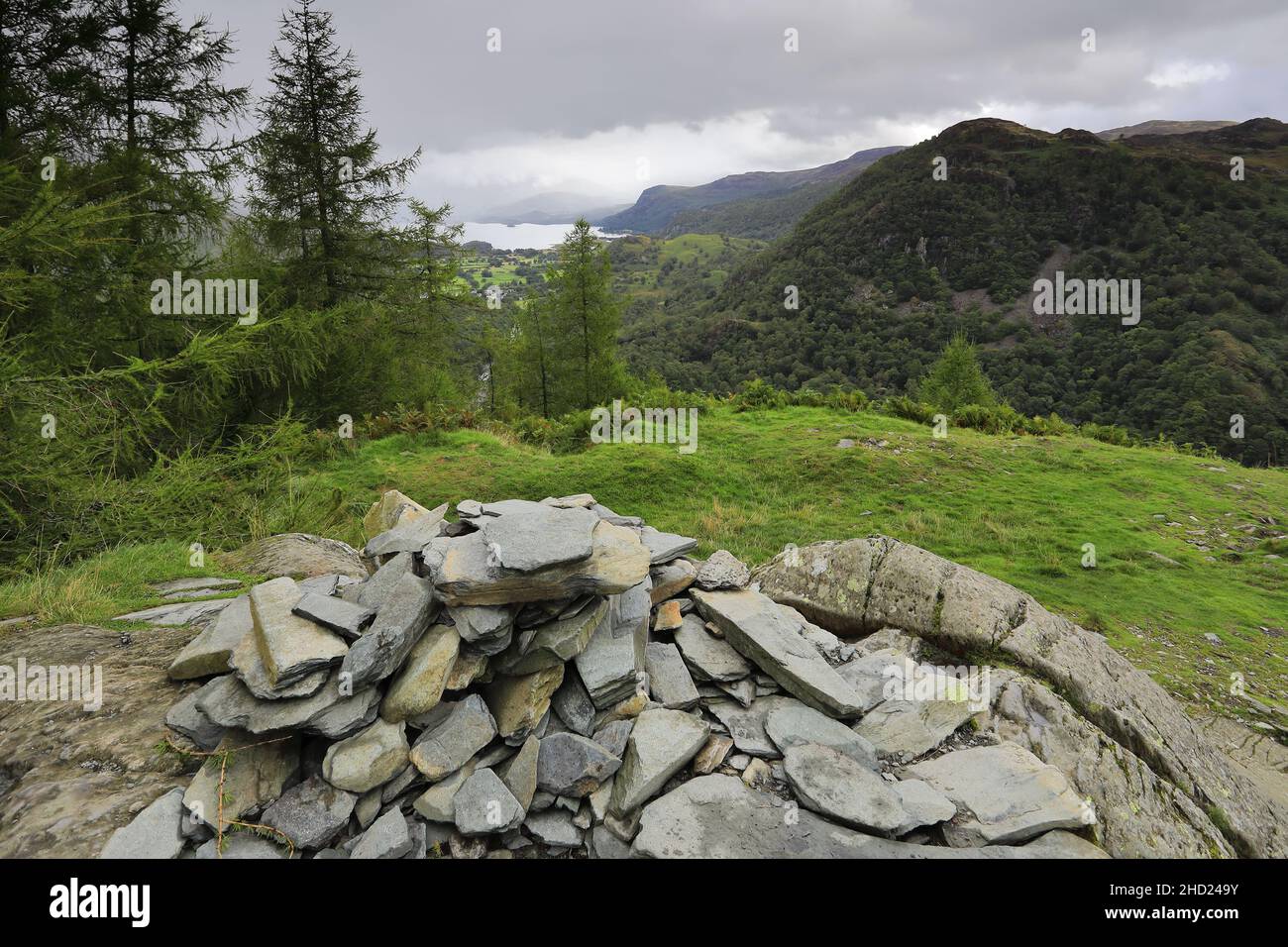 The summit cairn on Castle Crag fell above the Borrowdale pass valley ...