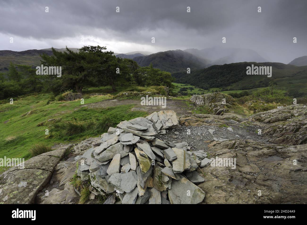 The summit cairn on Castle Crag fell above the Borrowdale pass valley ...