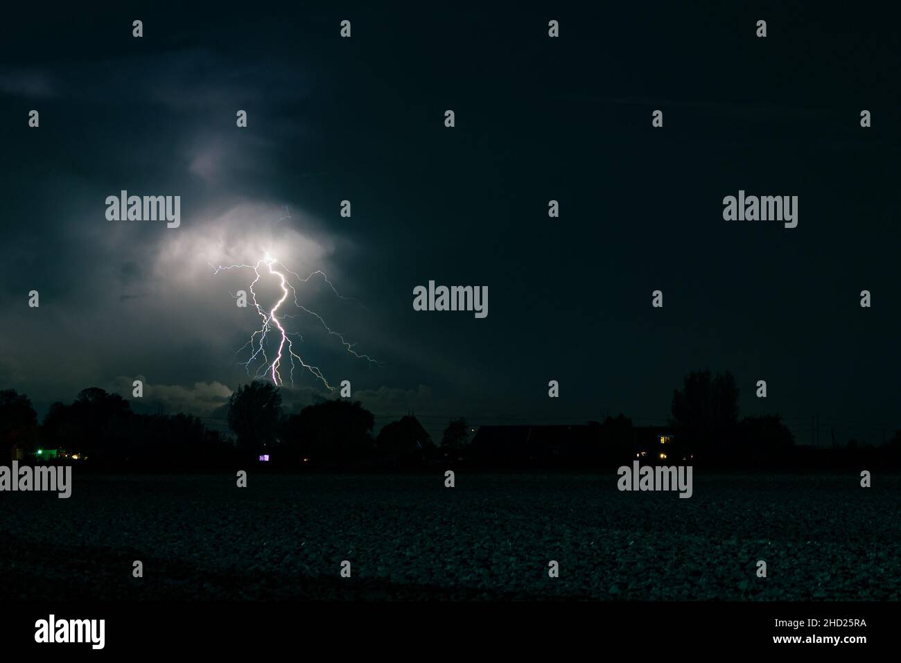Lightning strikes down from a distant storm cloud Stock Photo - Alamy