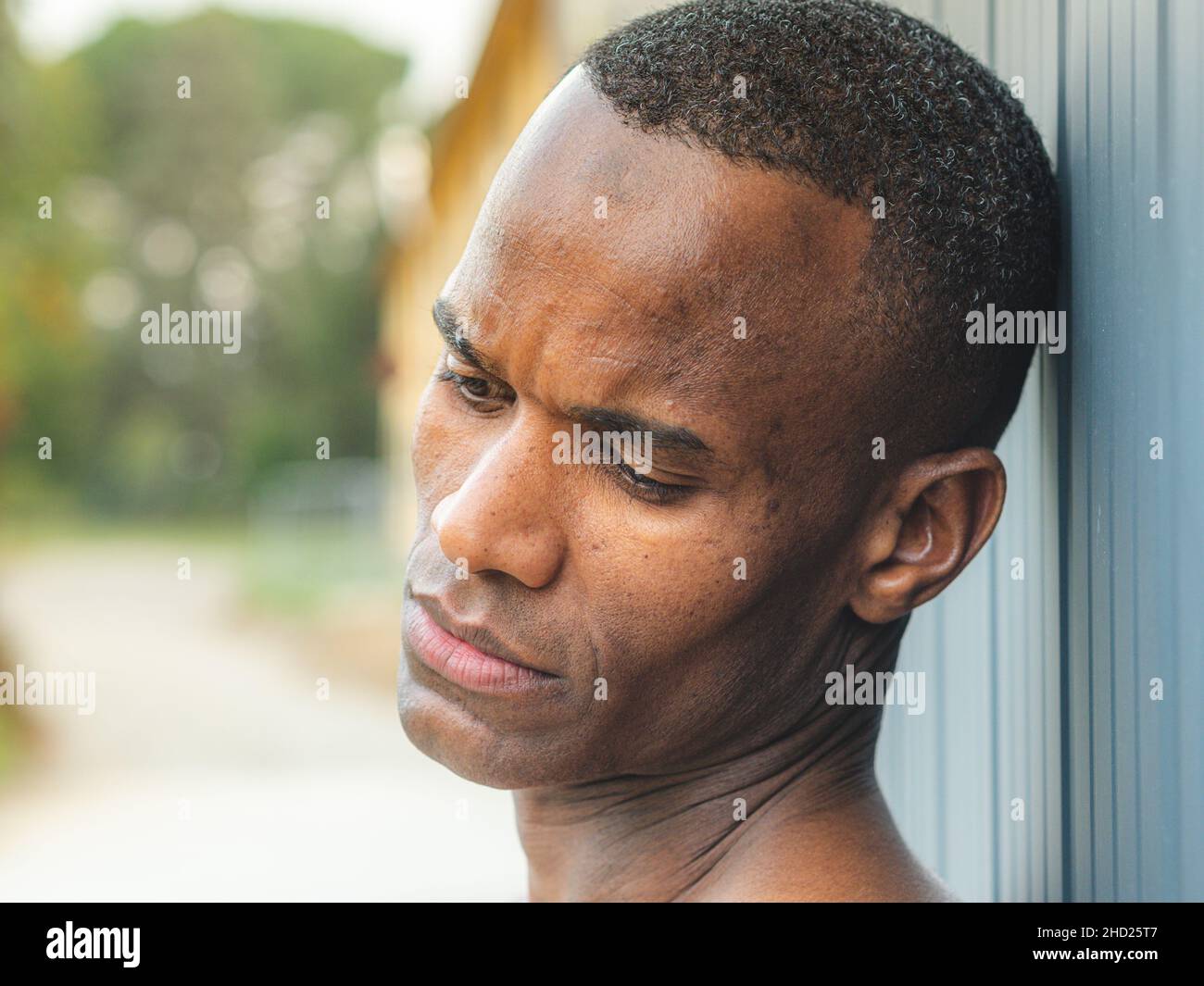 Portrait of a brooding African man leaning his head on the wall Stock ...