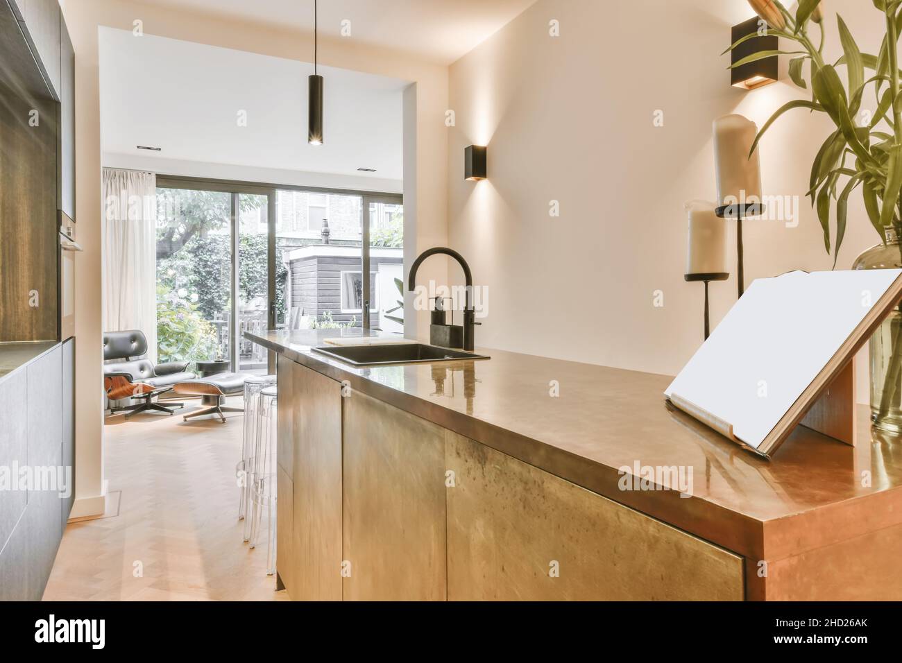 Rectangular kitchen with dark kitchen unit and countertop with stools ...