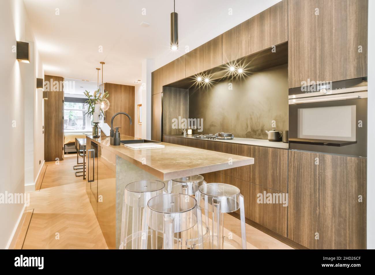Rectangular kitchen with dark kitchen unit and countertop with stools ...