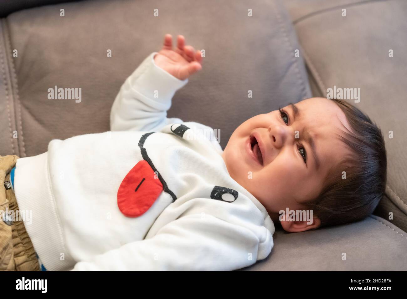Baby crying with the pain of his first teeth Stock Photo - Alamy