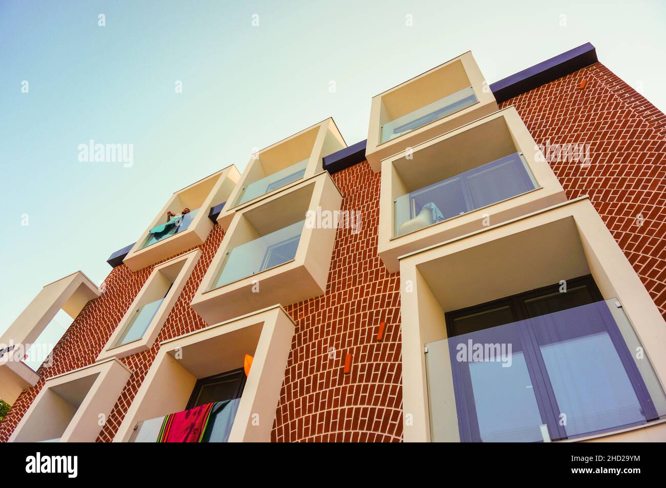 Low angle of rows of windows on an apartment building with red patterns ...